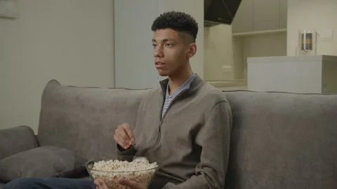 Black Man Eating Popcorn Sitting on Couc... | Stock Video | Pond5