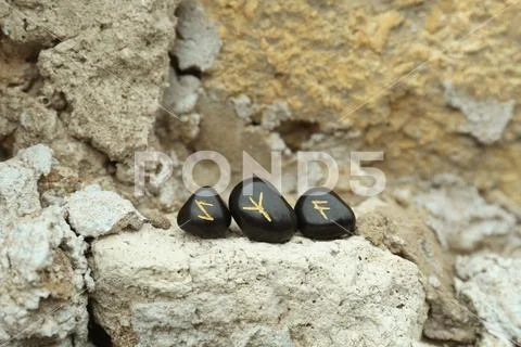 Photograph: Black runes on stone outdoors. Old Germanic alphabet #245522952