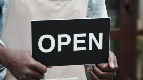 Black Sign with White Word Open in Hands... | Stock Video | Pond5