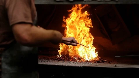 Blacksmith heating metal rod in fire 4k | Stock Video | Pond5