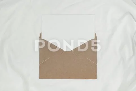 Blank white paper is placed on the open brown paper envelope on white ...