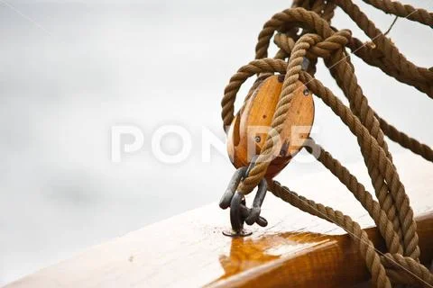 Block and ropes connecting to a railing on an old fishing vessel. Block ...