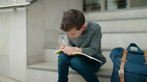 Blond child student writing on book sitt... | Stock Video | Pond5