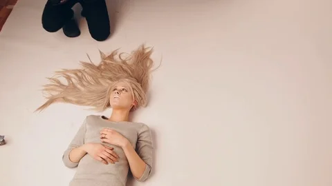 Blonde model girl lying in photo studio ... | Stock Video | Pond5