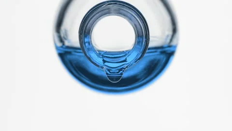 Blue oil is dripping from reagent bottle... | Stock Video | Pond5