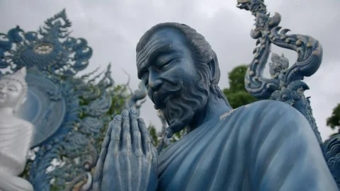 Blue stone statue of praying votarist at... | Stock Video | Pond5
