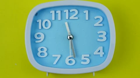 Blue table clock on a yellow background. | Stock Video | Pond5