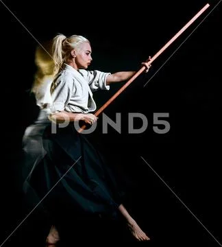 Photograph: Bo-Jutsu budoka woman isolated black background #117050282