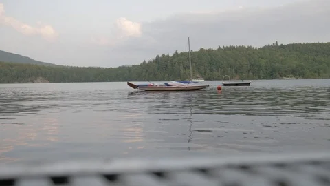 boat floating out in a lake, filmed from... | Stock Video | Pond5