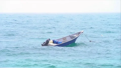 Boat floating out in the sea, tied to a ... | Stock Video | Pond5