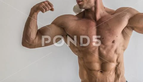 Bodybuilder flexing his muscles in studio. The torso of attractive male ...