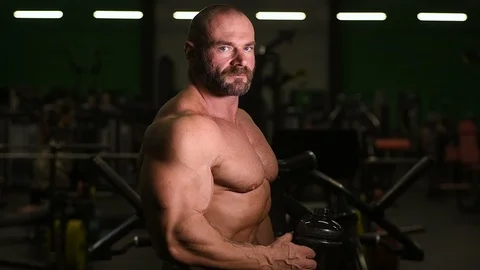 Bodybuilder pumping up muscles workout f... | Stock Video | Pond5