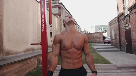 A bodybuilder stands on a sportground an... | Stock Video | Pond5