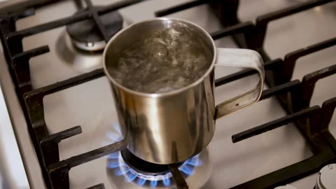 Boil water in a metal cup. A cup of wate... | Stock Video | Pond5
