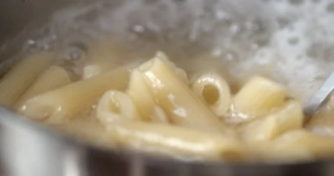 Boiled penne pasta stirred with a spoon ... | Stock Video | Pond5