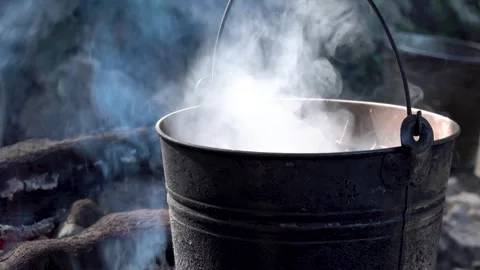 Boiling water in metal bucket on a smold... | Stock Video | Pond5