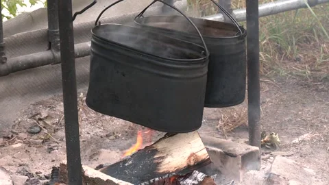 Boiling water on red hot coals in forest... | Stock Video | Pond5