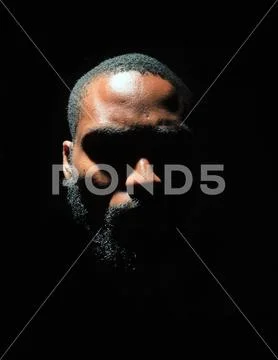 Bold black African bearded face isolated on a black background Stock ...