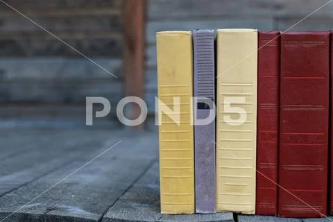 Books standing on a table books standing different objects on a wooden ...