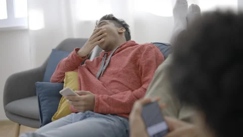 Bored teen boy scrolling smartphones and... | Stock Video | Pond5