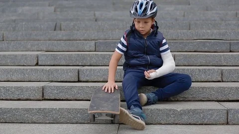 Bored white boy with broken arm | Stock Video | Pond5