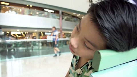 Boring Boy looks at crowd walking in sho... | Stock Video | Pond5