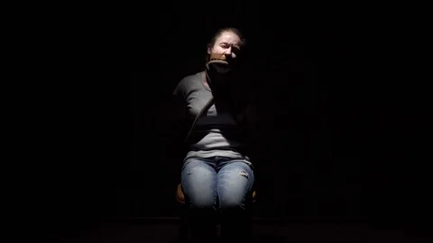 bound prisoner to chair sits in dark roo... | Stock Video | Pond5