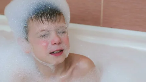 Boy 6-7 years dives into a bubble bath, ... | Stock Video | Pond5