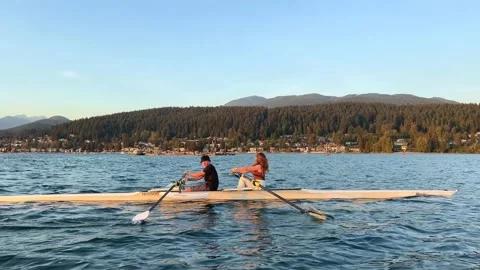 a boy and a girl are rowing on a long wh... | Stock Video | Pond5