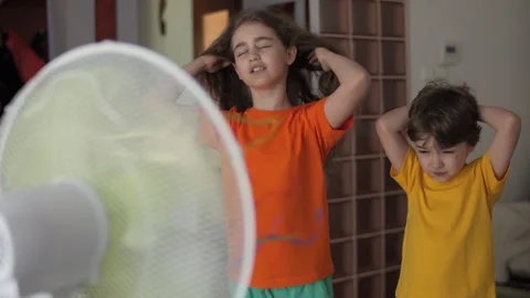Boy and Girl in Front Fan Hot Day on Hom... | Stock Video | Pond5