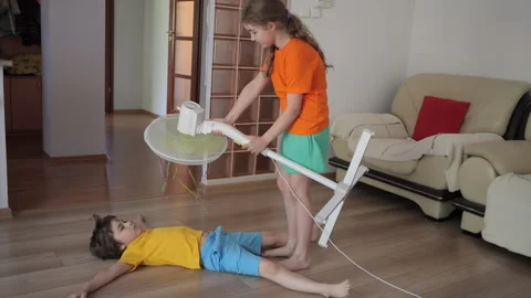 Boy and Girl in Front Fan Hot Day on Hom... | Stock Video | Pond5