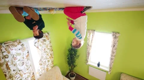 Boy and girl upside down sit on ceiling ... | Stock Video | Pond5