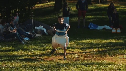 Boy and man running funny race on lawn i... | Stock Video | Pond5