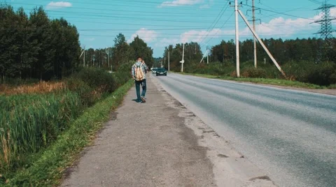 Boy with backpack walking along roadside... | Stock Video | Pond5