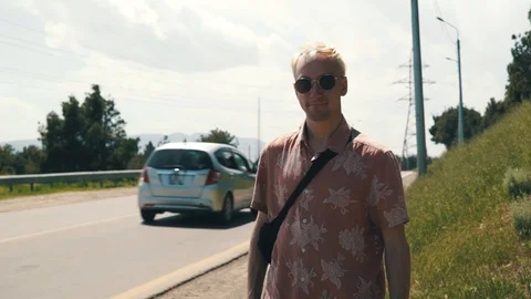 Boy with backpack walking along roadside... | Stock Video | Pond5