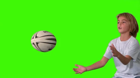 Boy catching rugby ball on green screen | Stock Video | Pond5