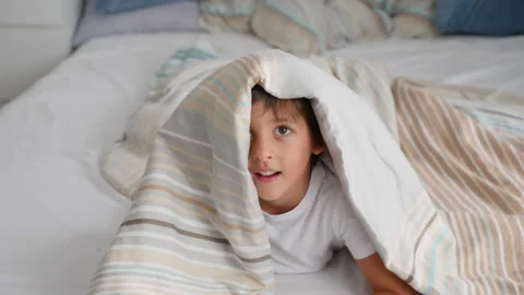 boy child is raging under a light blanke... | Stock Video | Pond5