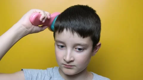 A boy is combing, brushing hair against ... | Stock Video | Pond5