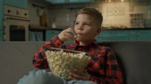 Boy Eating Popcorn Watching TV. Child en... | Stock Video | Pond5
