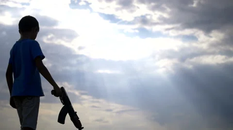boy with a gun at sunset on the backgrou... | Stock Video | Pond5