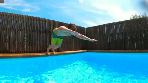 Boy headfirst jumping in pool refreshing... | Stock Video | Pond5