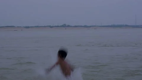 Boy jumping in the ganges river in varan... | Stock Video | Pond5
