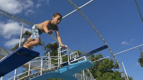 Boy jumping from springboard and diving ... | Stock Video | Pond5