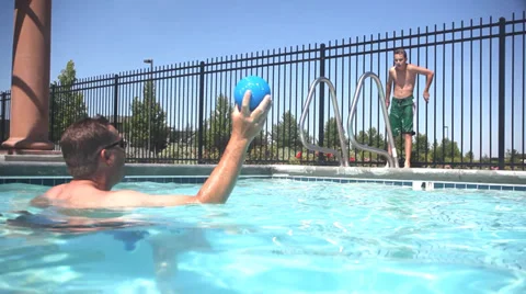 Boy jumps into pool and catches ball | Stock Video | Pond5