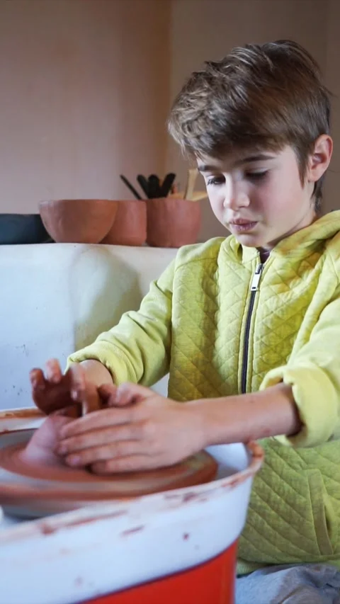 Boy learning to shape clay to make potte... | Stock Video | Pond5