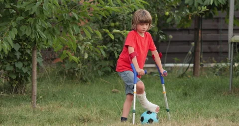 Boy with leg in cast stands on crutches,... | Stock Video | Pond5