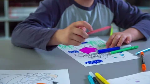 Boy painting a colouring book | Stock Video | Pond5