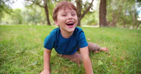 Boy rolling in grass in slow motion | Stock Video | Pond5