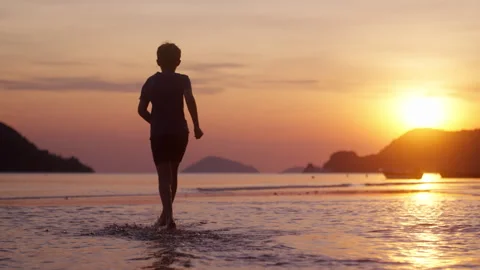 Boy Running Slowly In The Shallow Sea Wa... | Stock Video | Pond5