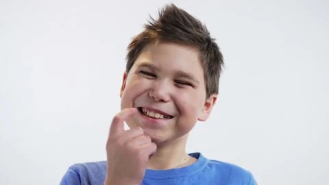 Boy showing his teeth on white backgroun... | Stock Video | Pond5